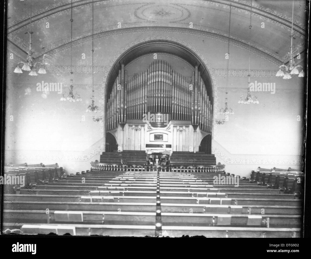 This interior view of a church, featuring a prominent pipe organ ...