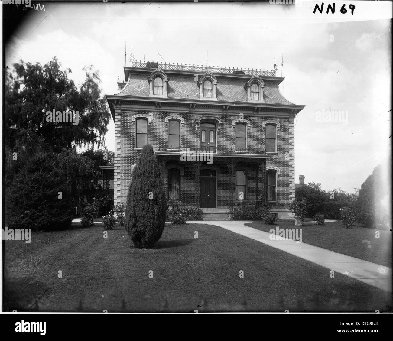 This photograph shows an unidentified Italianate-style brick house, a ...