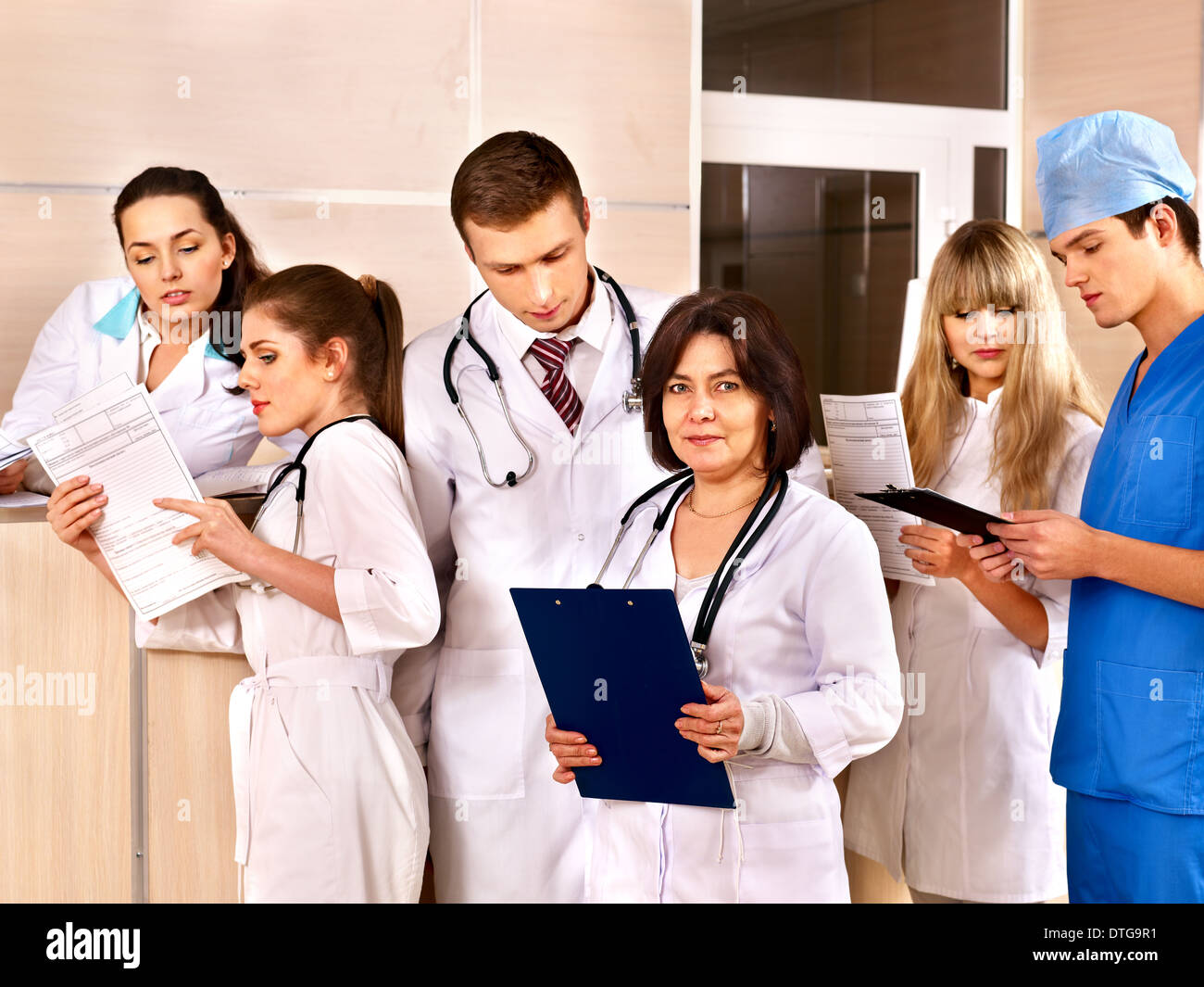 Group doctors and patient standing at reception in hospital Stock Photo ...
