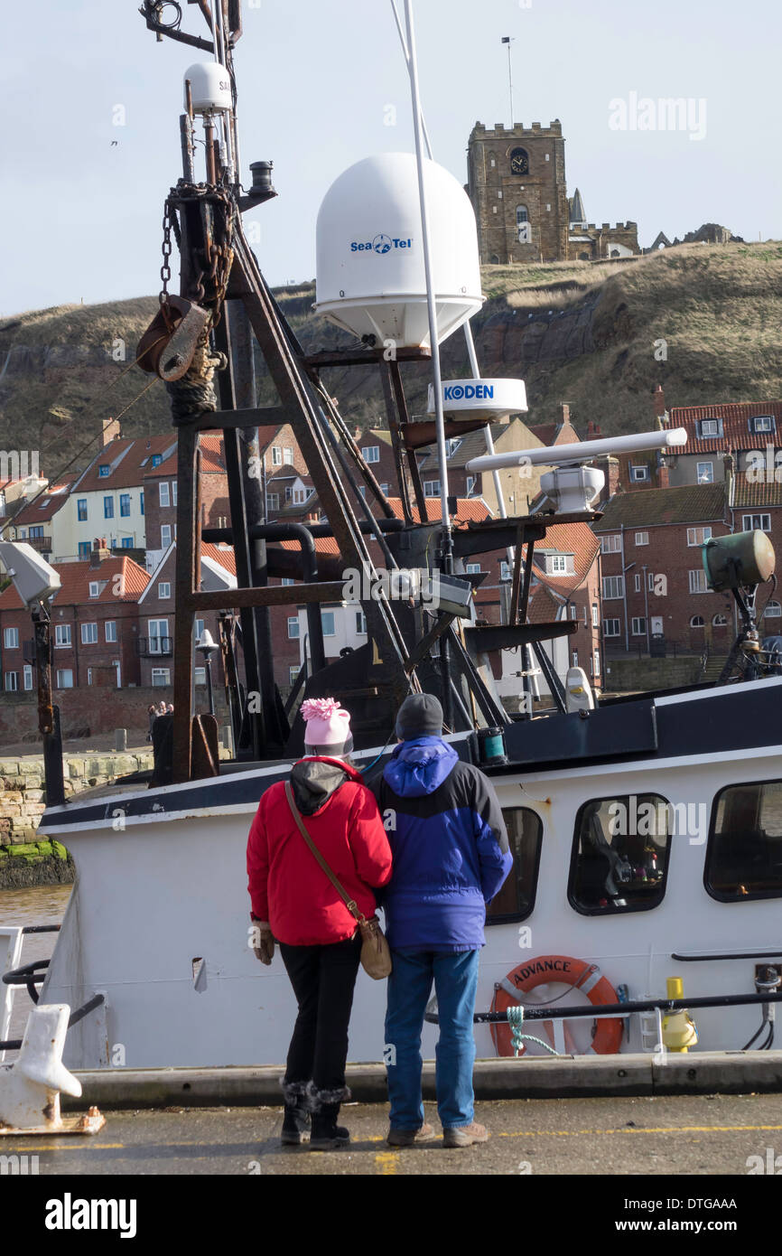 Tourist couple admire large fishing boat "Advance" moored at the Fish ...
