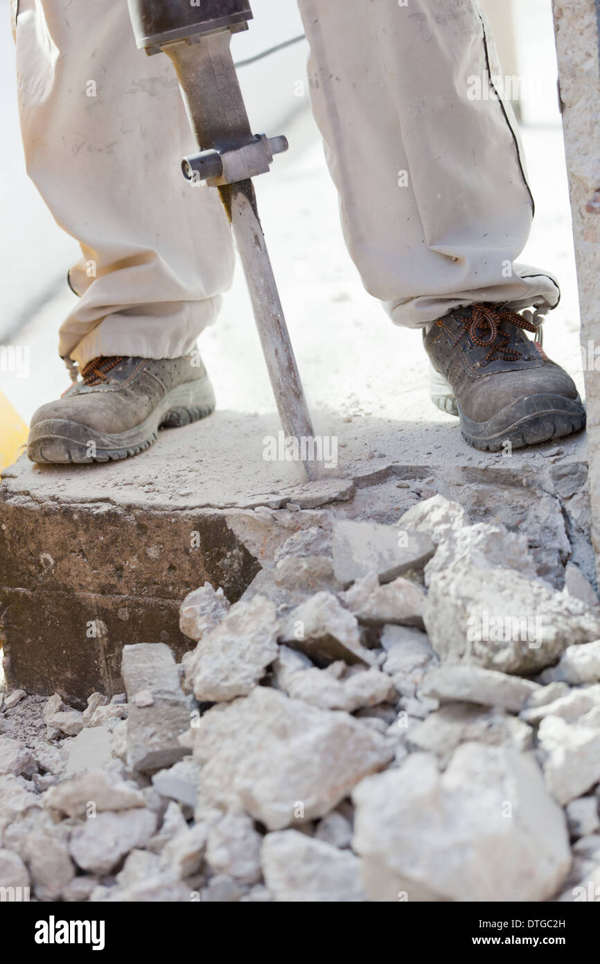 Worker demolishing the concrete with a jackhammer Stock Photo - Alamy