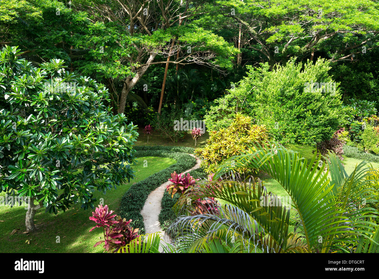 A walking path around a tropical resorts lush garden grounds shows ...