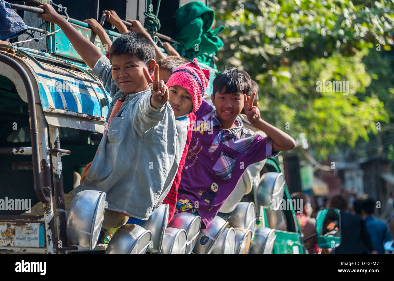 MANDALAY, MYANMAR - CIRCA DECEMBER 2013: Happy Burmese children riding ...