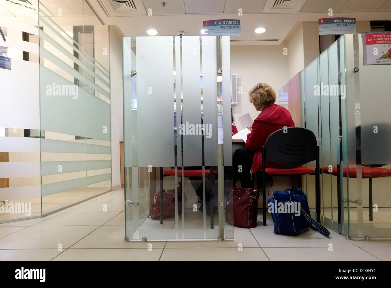 Customer and bank teller in cubicle inside Bank Hapoalim in Jerusalem ...