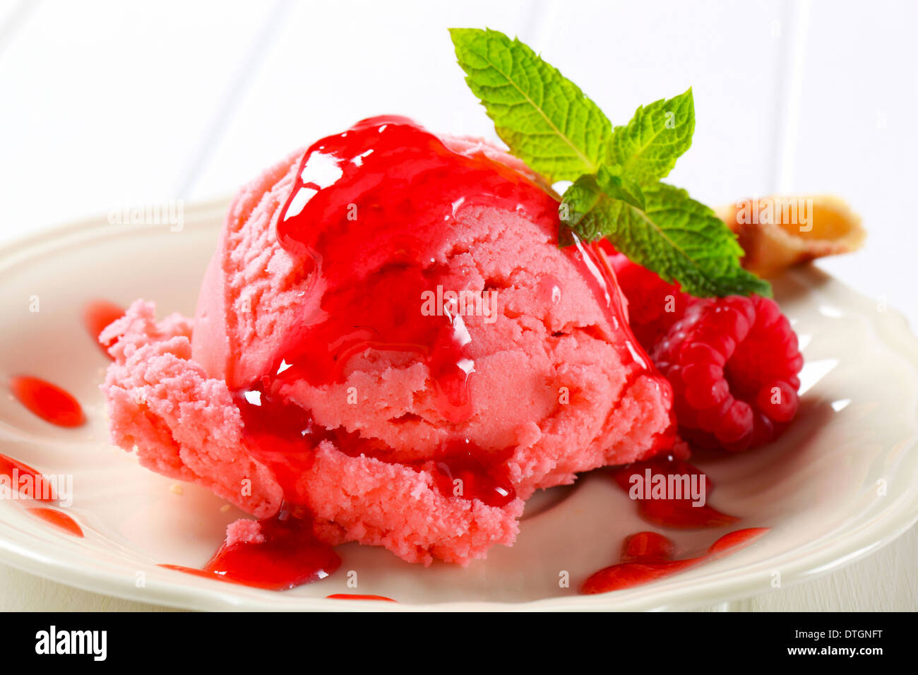 Scoop of pink ice cream with raspberry sauce Stock Photo - Alamy