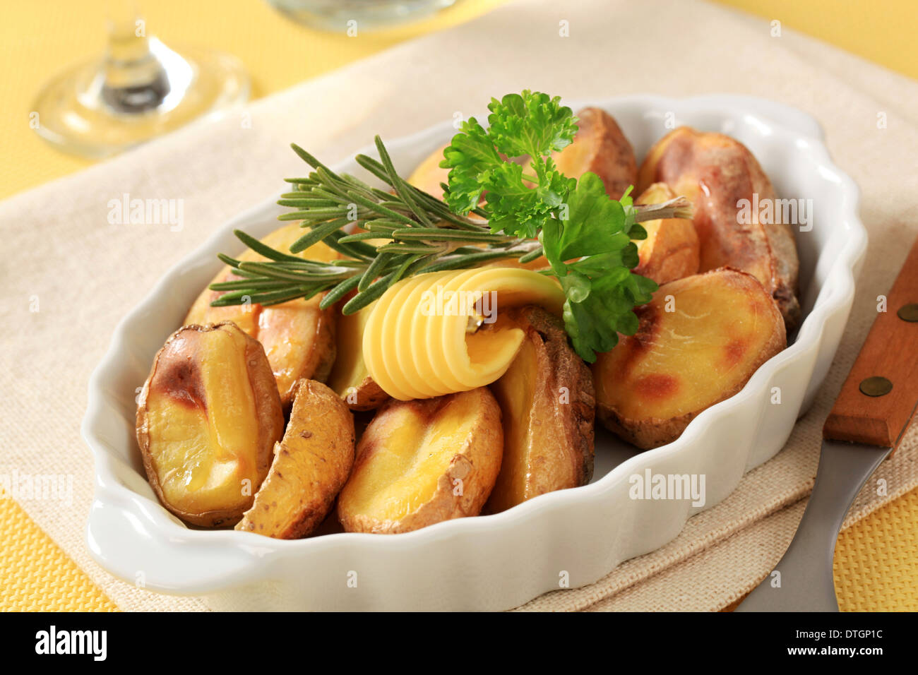 Halves of roasted unpeeled potatoes in a casserole dish Stock Photo - Alamy