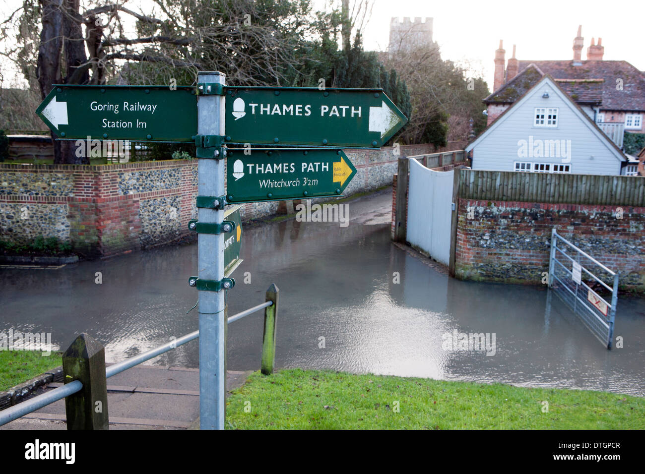 Flood water from the River Thames blocking the Thames Path, road sign ...