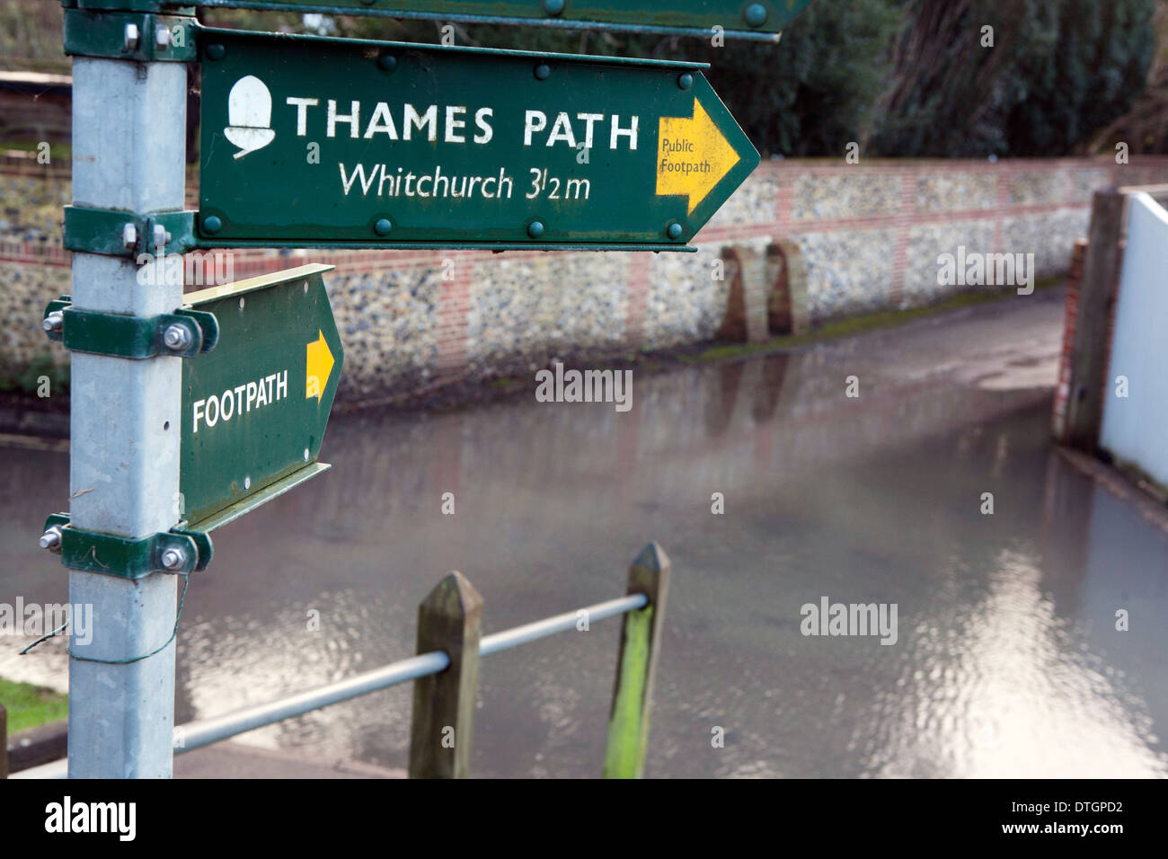 Flood water from the River Thames blocking the Thames Path, road sign ...