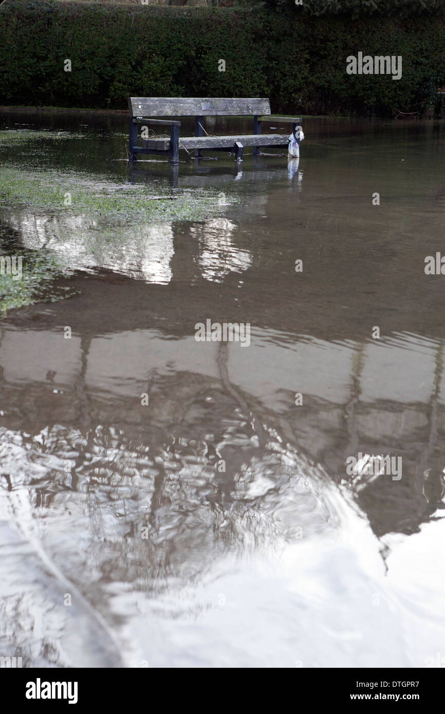 Flooded footpath with single park bench under flood water from the ...