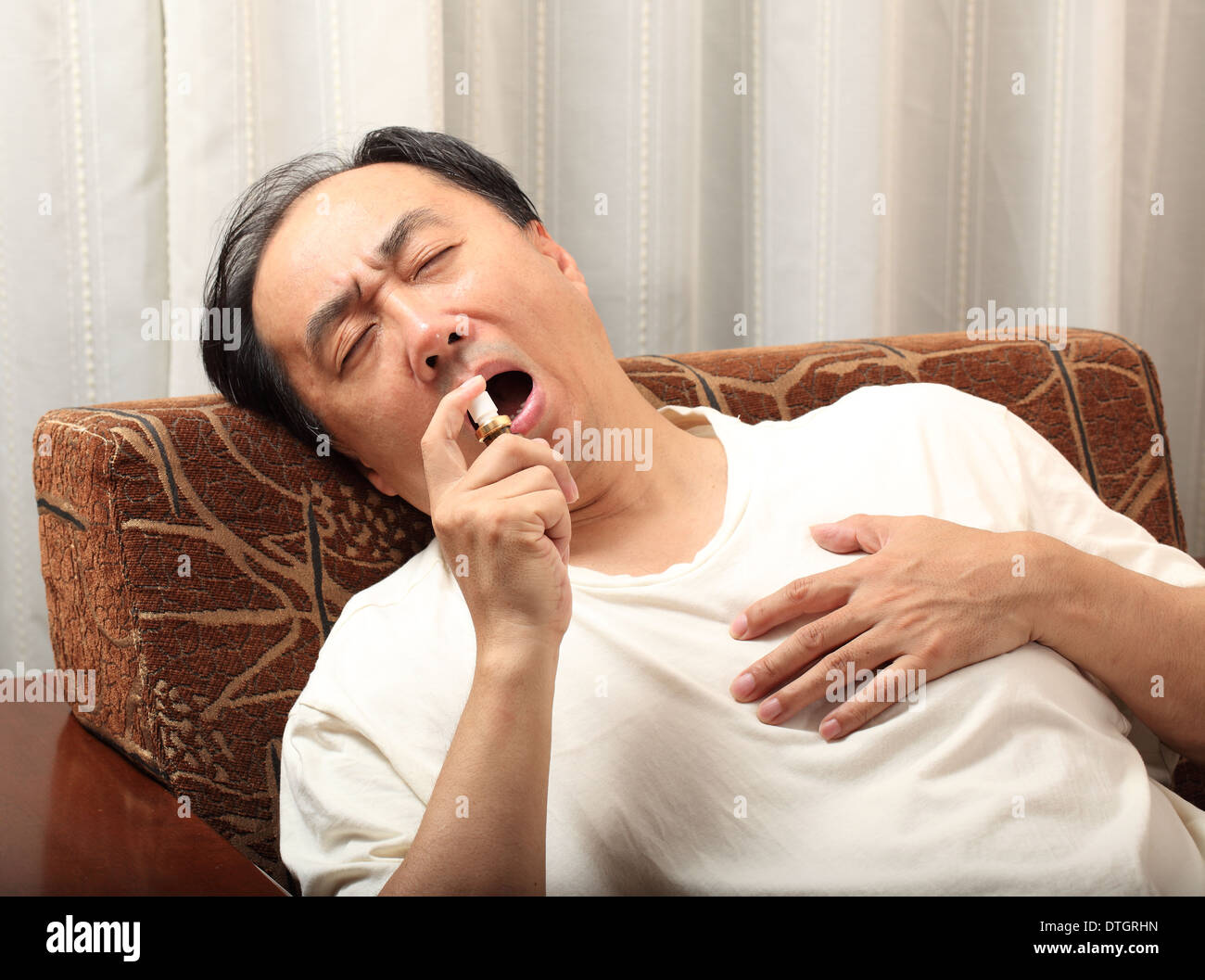 Asian man with a heart attack, holding his chest Stock Photo - Alamy