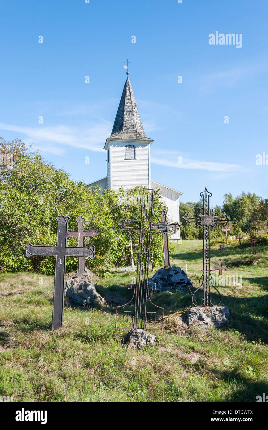 Old rusty metal crosses at graveyard and white church in background ...