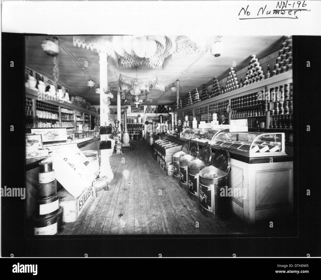 This historical photograph shows the interior of a grocery store ...