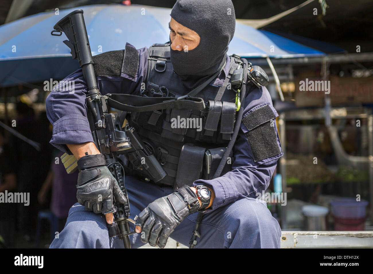 Bangkok, Thailand. 18th Feb, 2014. A Thai riot police officer with his ...