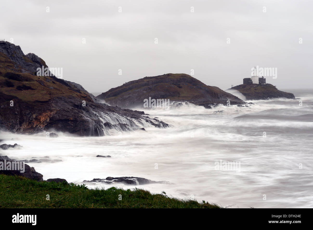 storm surf surges over the islands at Mumbles Head at high tide with ...
