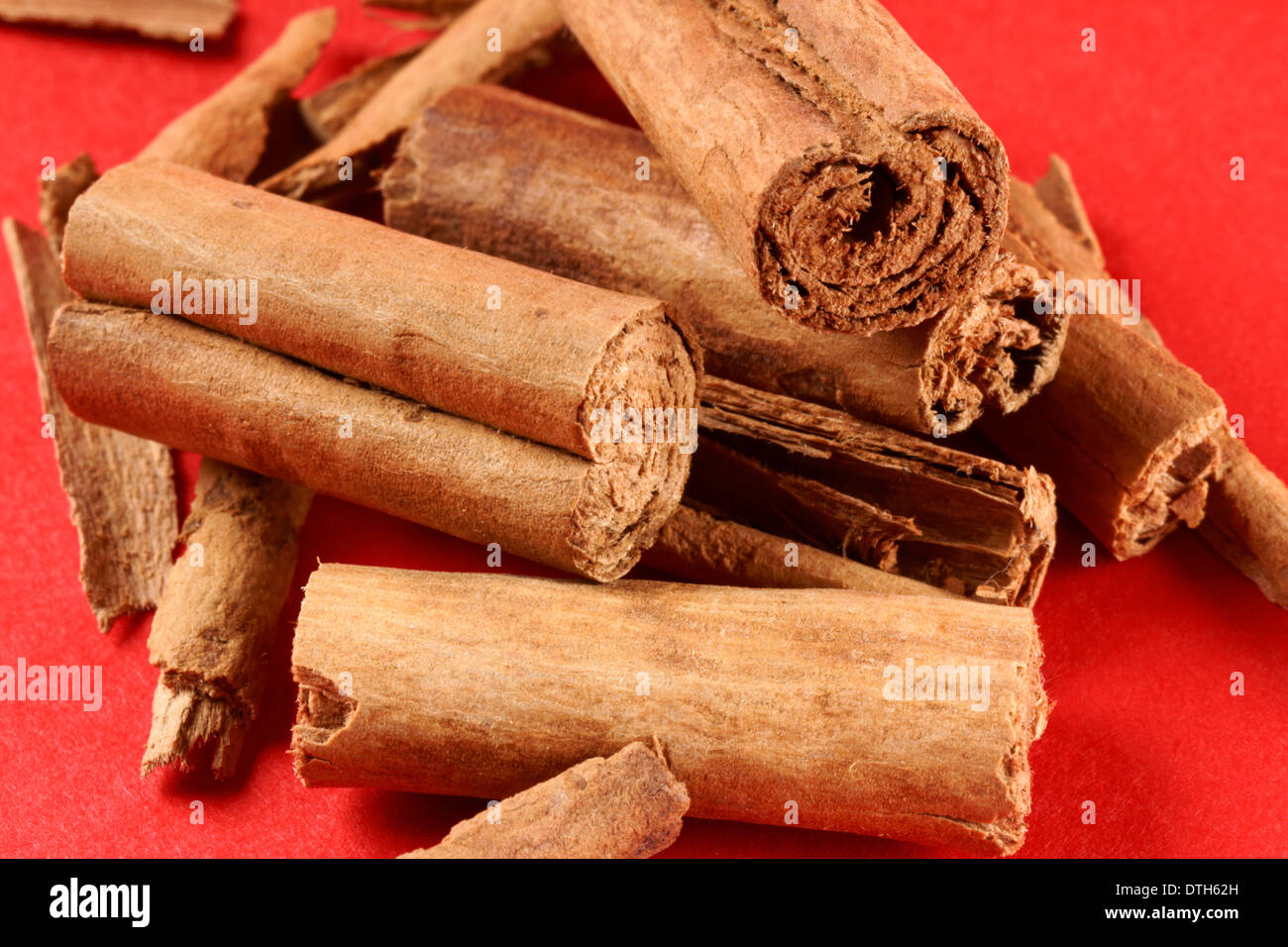 Cinnamon sticks over a red paper background Stock Photo - Alamy