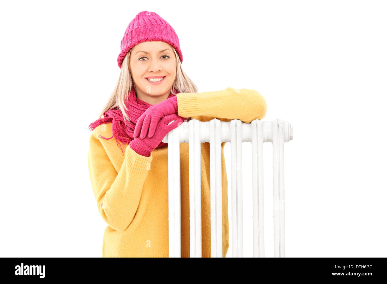 Young woman in winter clothes sitting next to a radiator Stock Photo ...