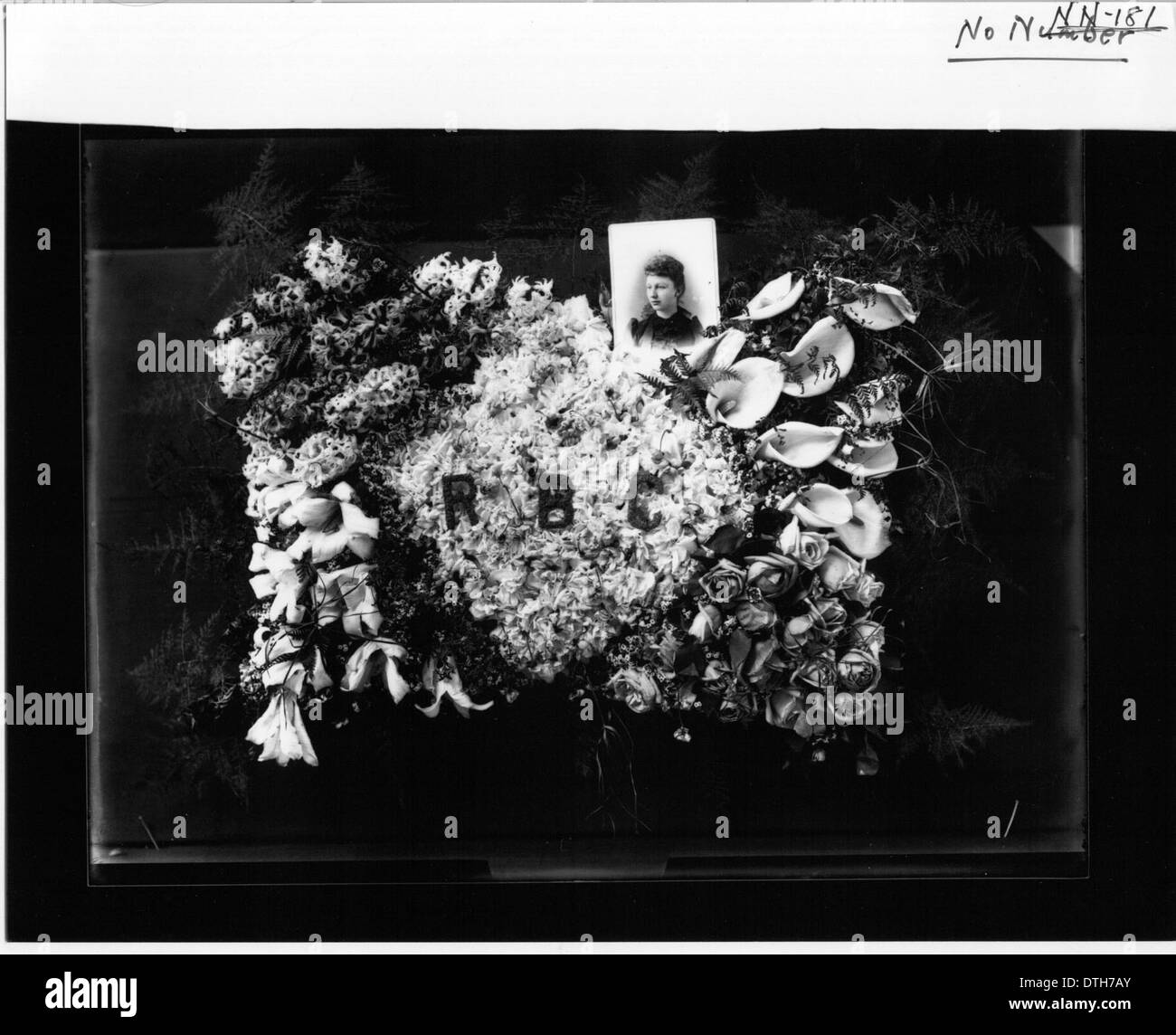 This photograph depicts a memorial arrangement of flowers alongside a ...