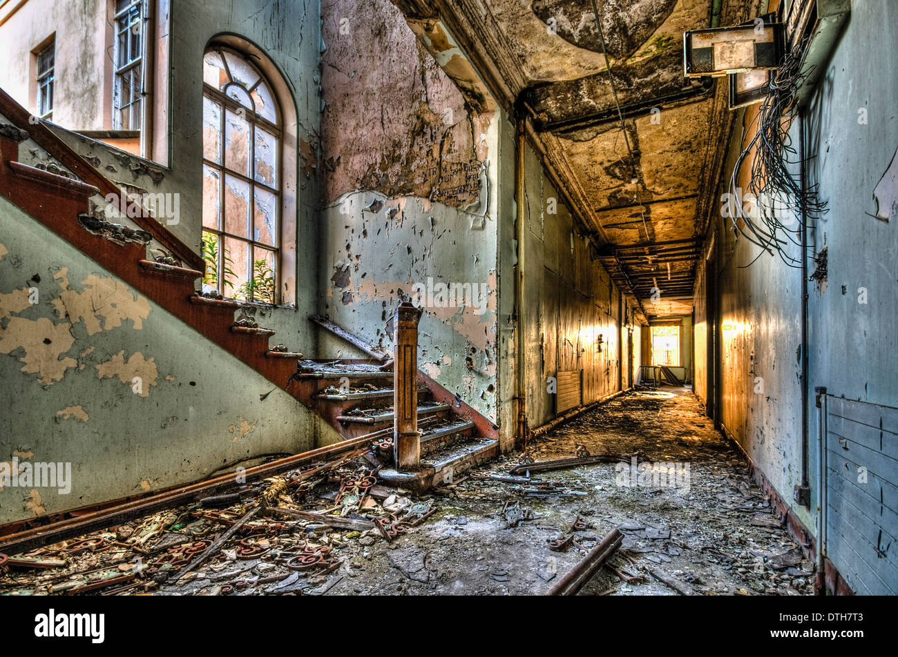 Corridor in a derelict building, with sunlight shining through far ...