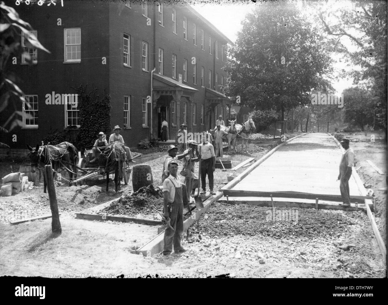 This photograph from 1913 shows a construction crew pouring cement for ...