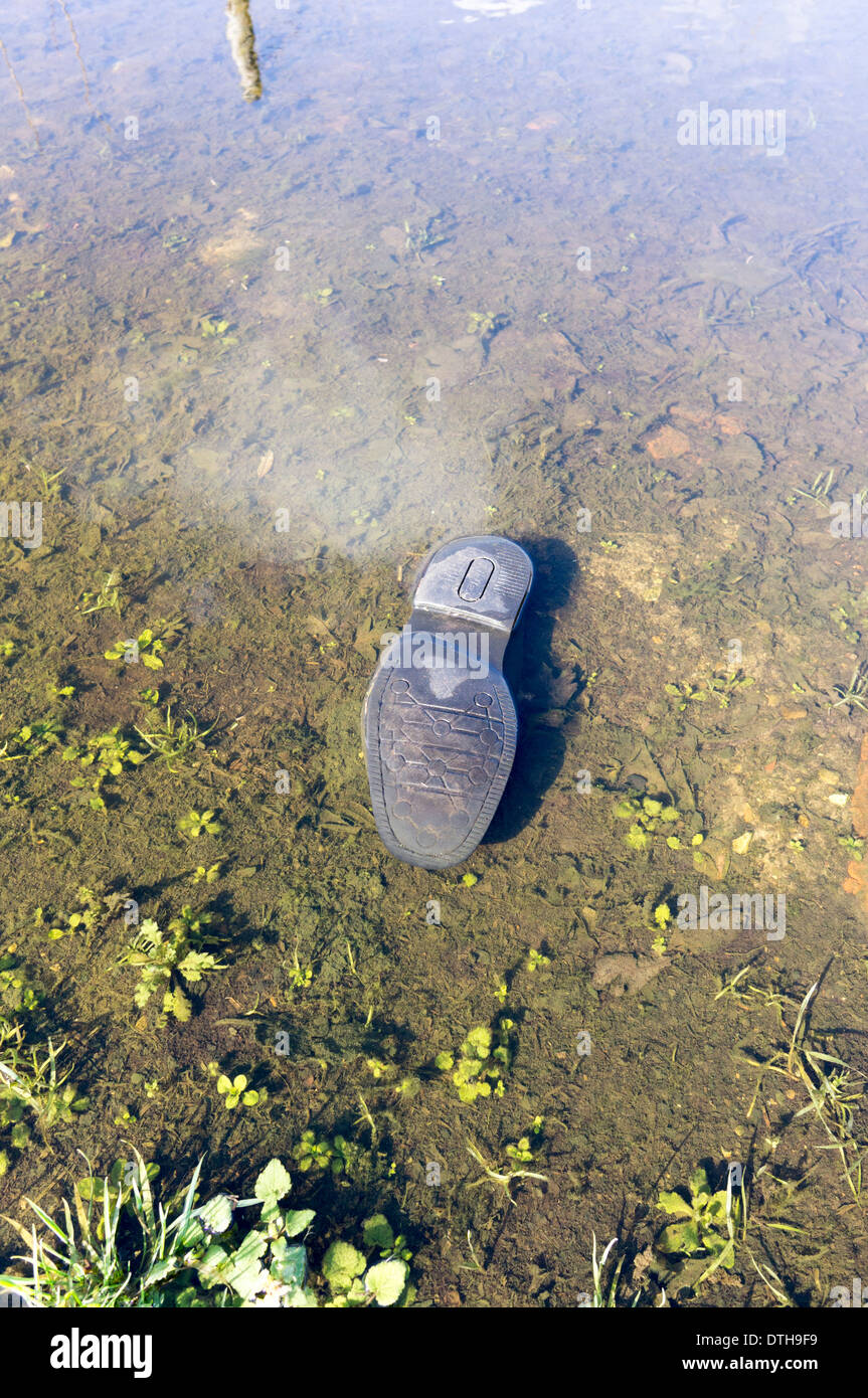 Discarded shoe upside down floating in flood water UK Stock Photo - Alamy