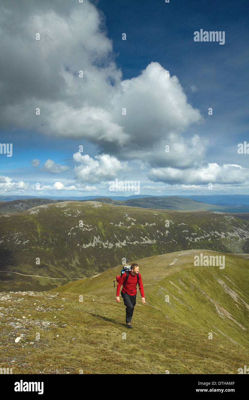 A walker ascending the Munro of A'Mharconaich above the Drumochter Pass ...