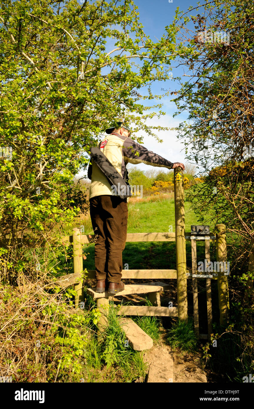 Man climbing over stile on the footpath approaching Castle Hill at ...