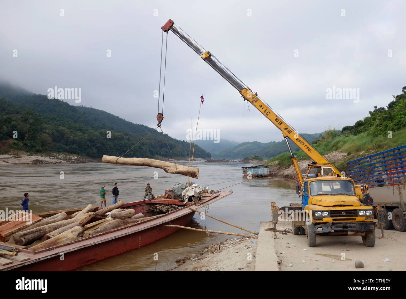 Loading logs onto a cargo boat on the Mekong River, Pakbeng, Laos Stock ...