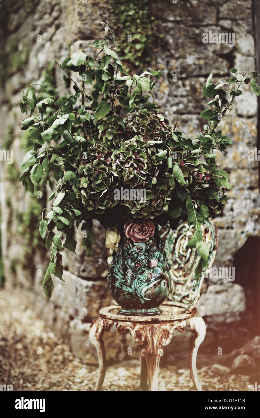rustic flower arrangements on location in a walled garden Stock Photo ...