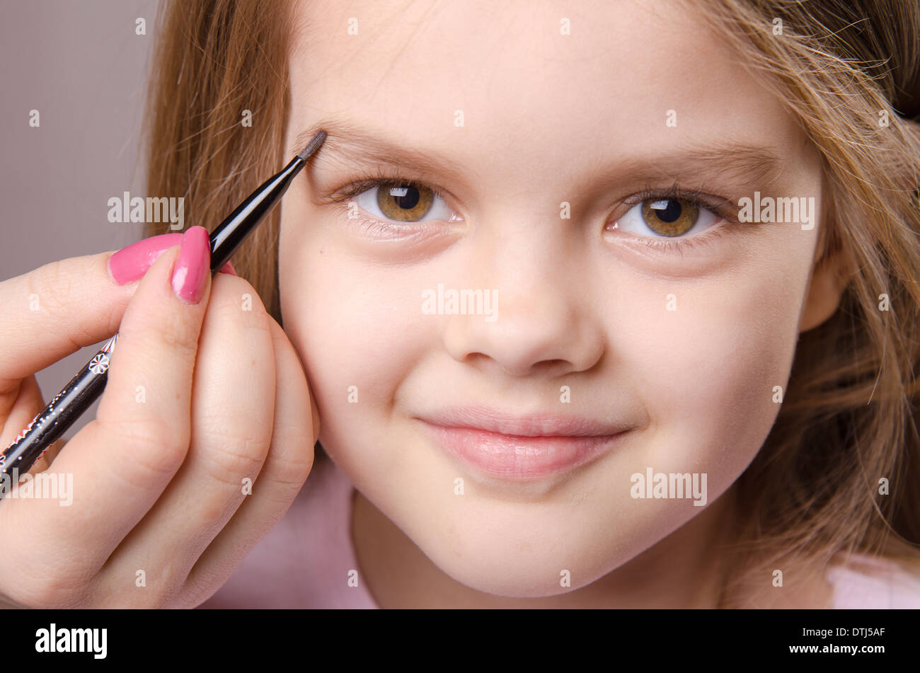 Makeup artist in the process of makeup brings eyebrows on the face five ...