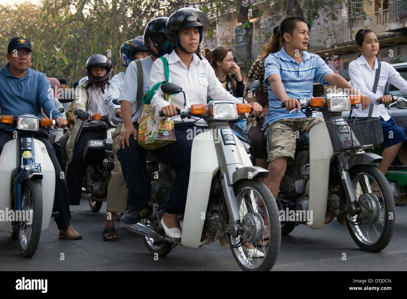 A group of people are riding motorcycles in heavy traffic on a busy ...