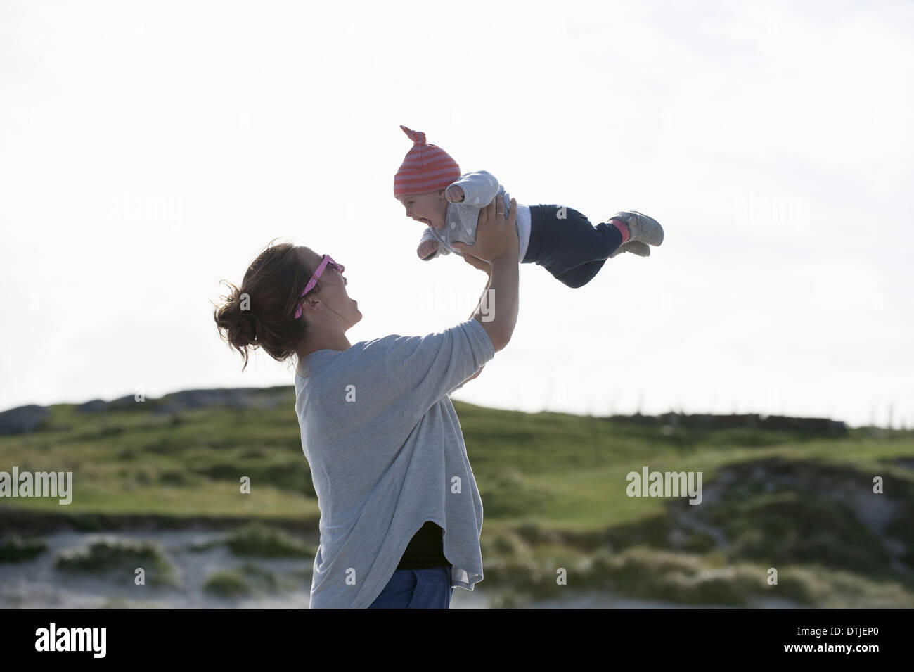 A mother raising her baby in the air At the seaside England Stock Photo ...
