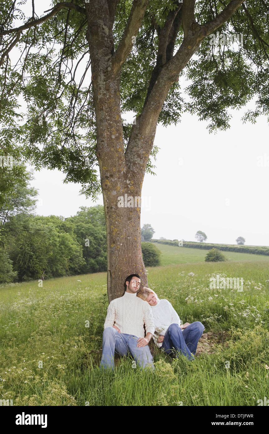Couple leaning against a tree hi-res stock photography and images - Alamy