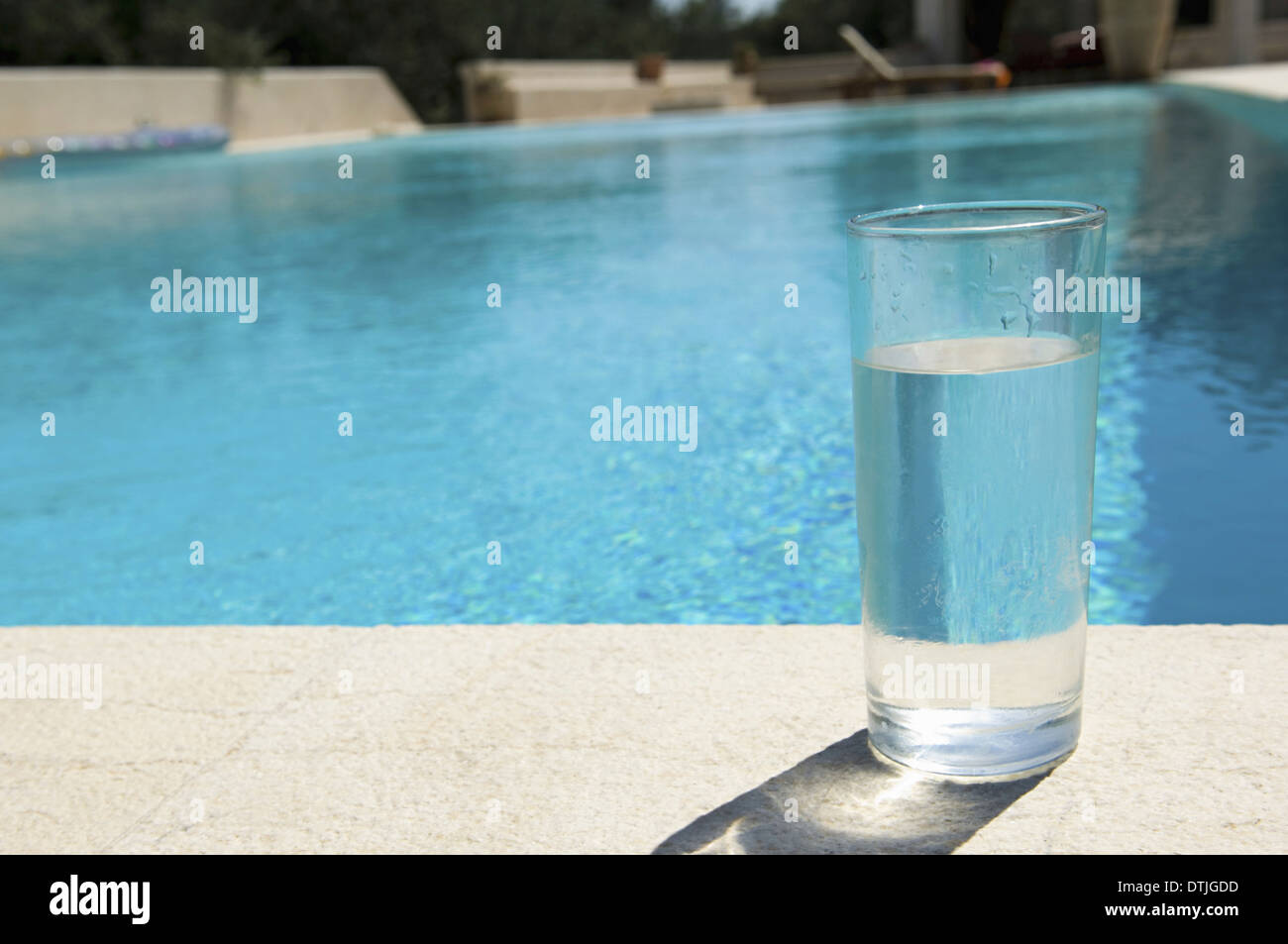 Glass of water on the side of a swimming pool England Stock Photo - Alamy