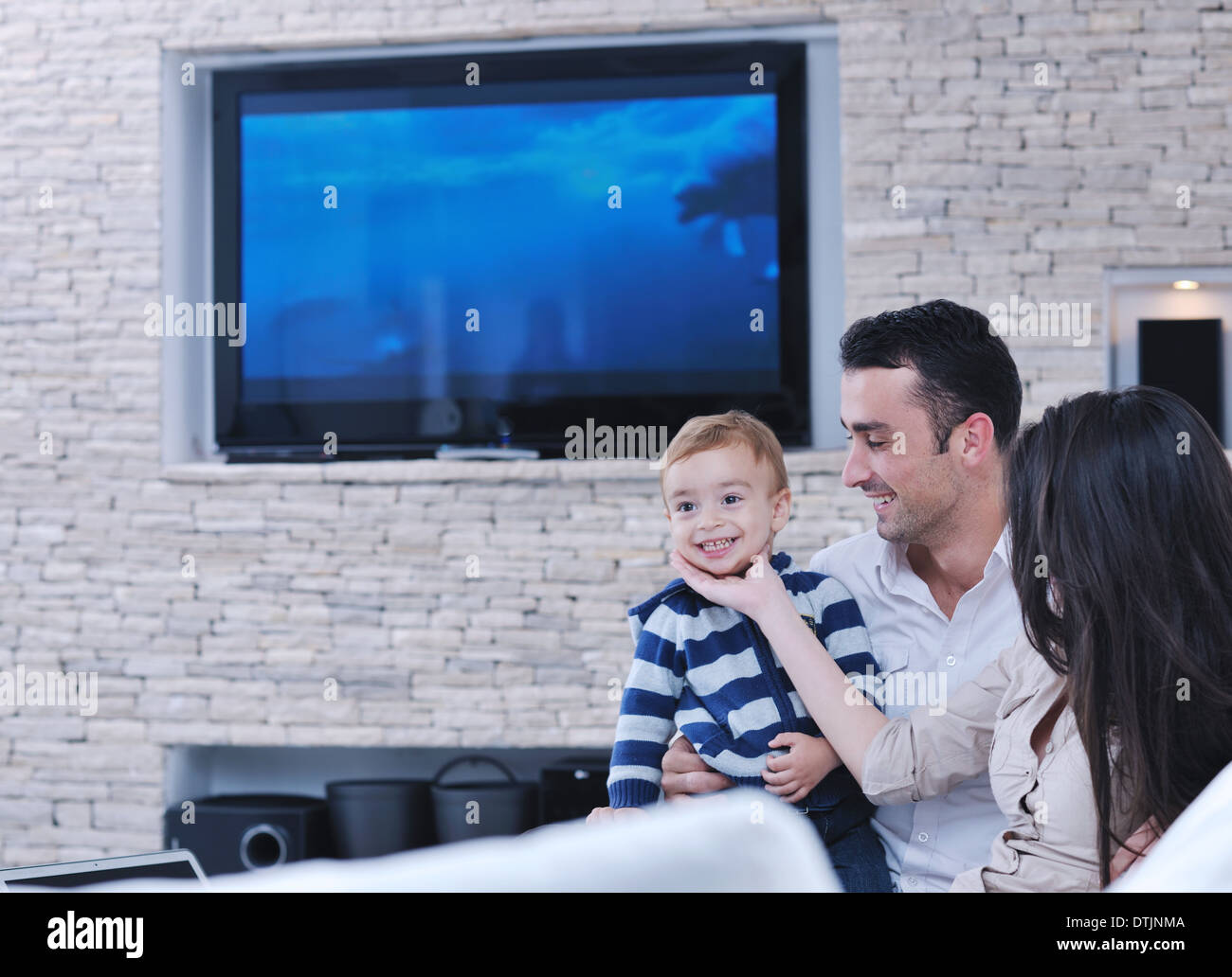 happy young family have fun with tv in backgrund Stock Photo - Alamy