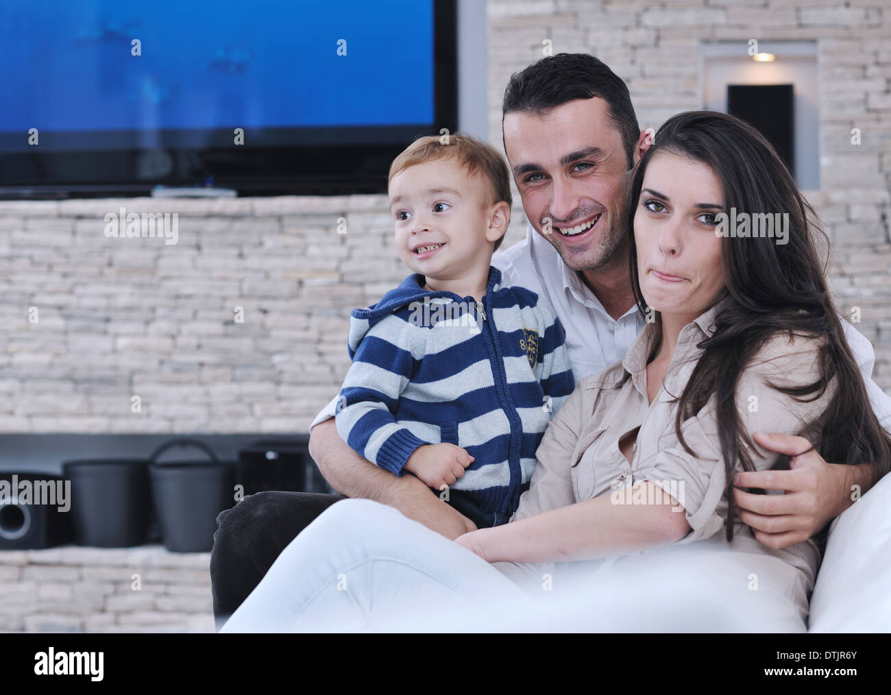 happy young family have fun with tv in backgrund Stock Photo - Alamy
