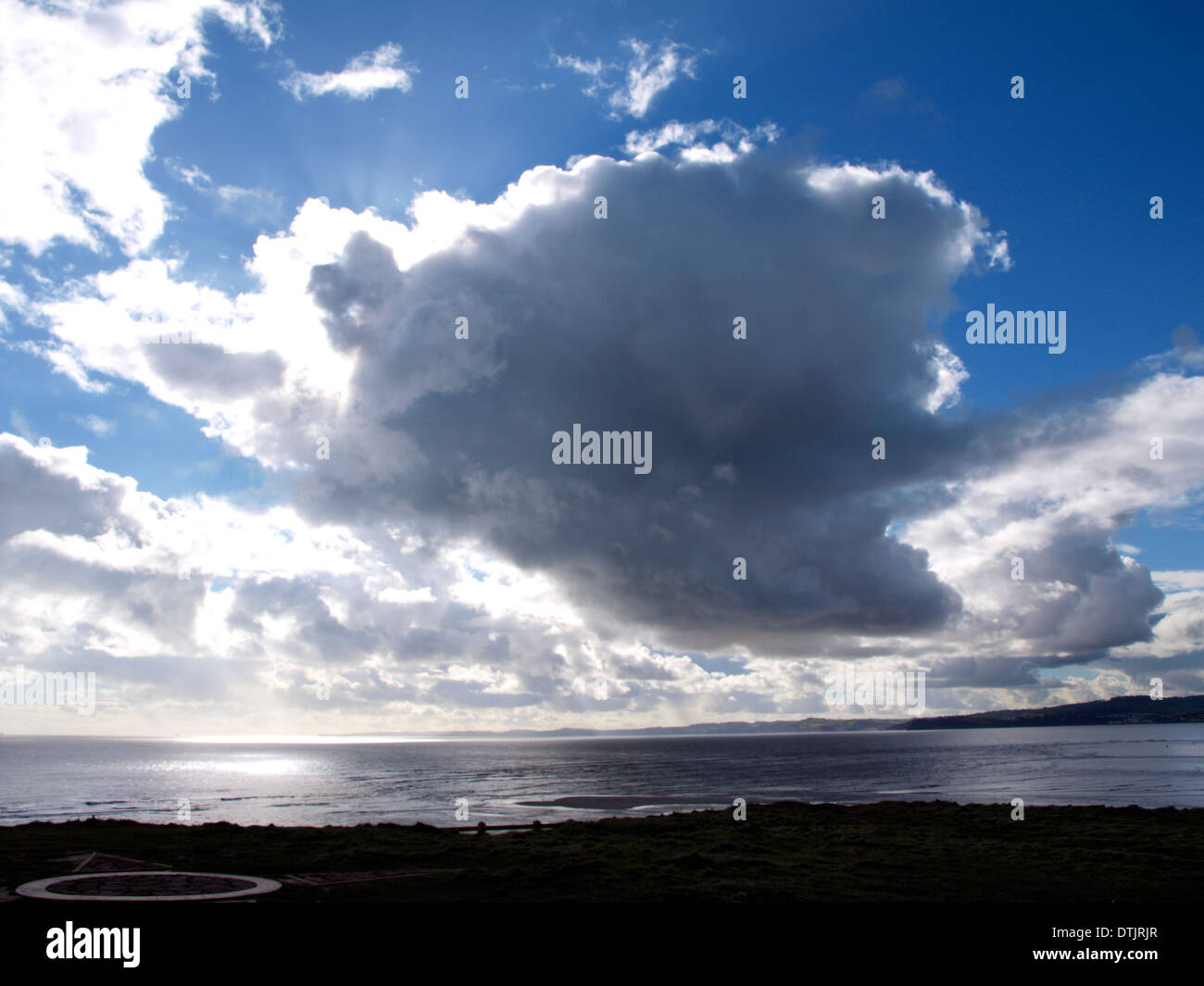 Sun going behind a large black rain cloud over the sea, Exmouth, Devon ...