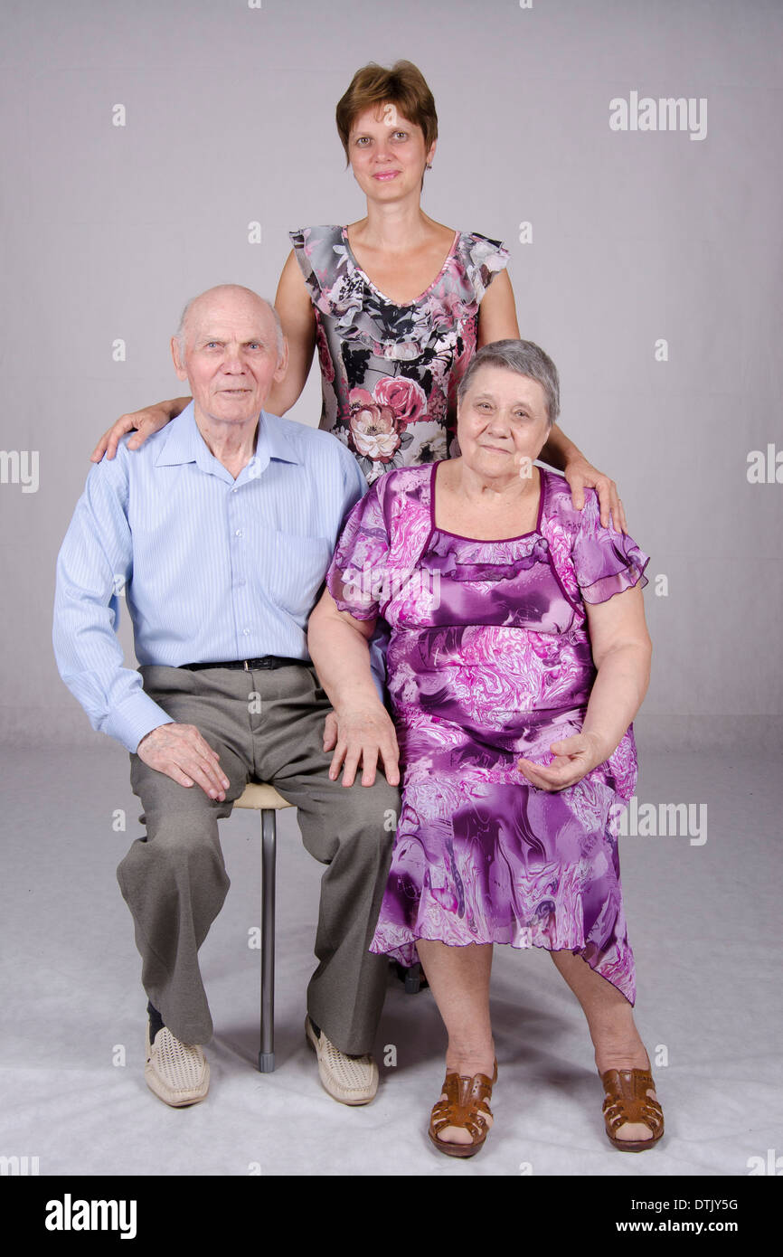 Group portrait of a family: a daughter and a little old mother and dad ...