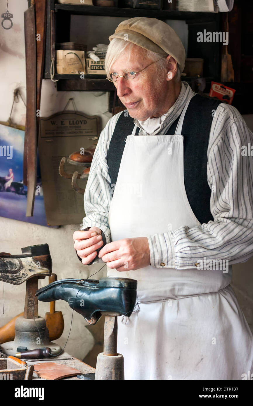 Man dressed in period costume working as a shoemaker in cobblers ...