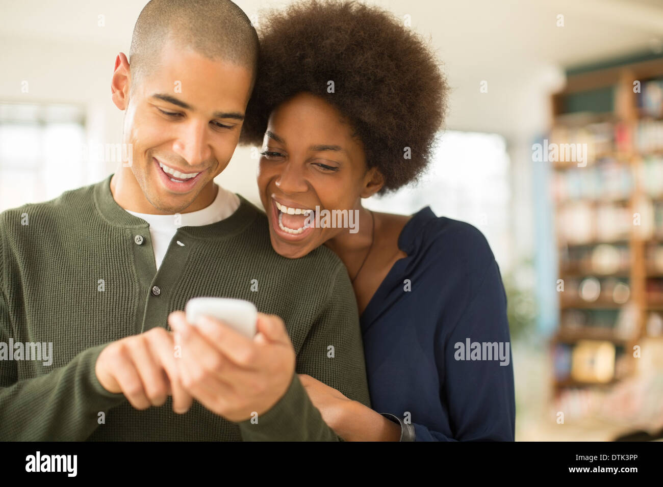 Couple using cell phone together Stock Photo - Alamy