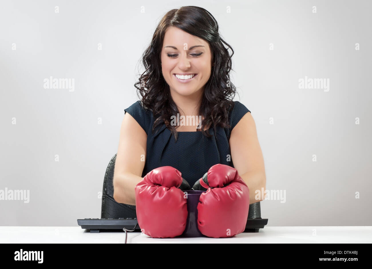 business woman sitting at a desk wearing boxing gloves Stock Photo - Alamy