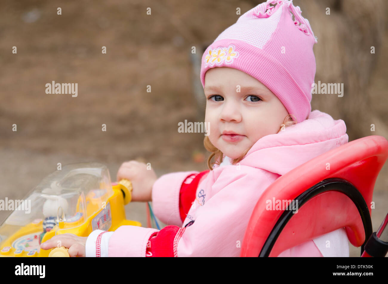 A little girl sat on the bike and turning looks in the frame. The ...