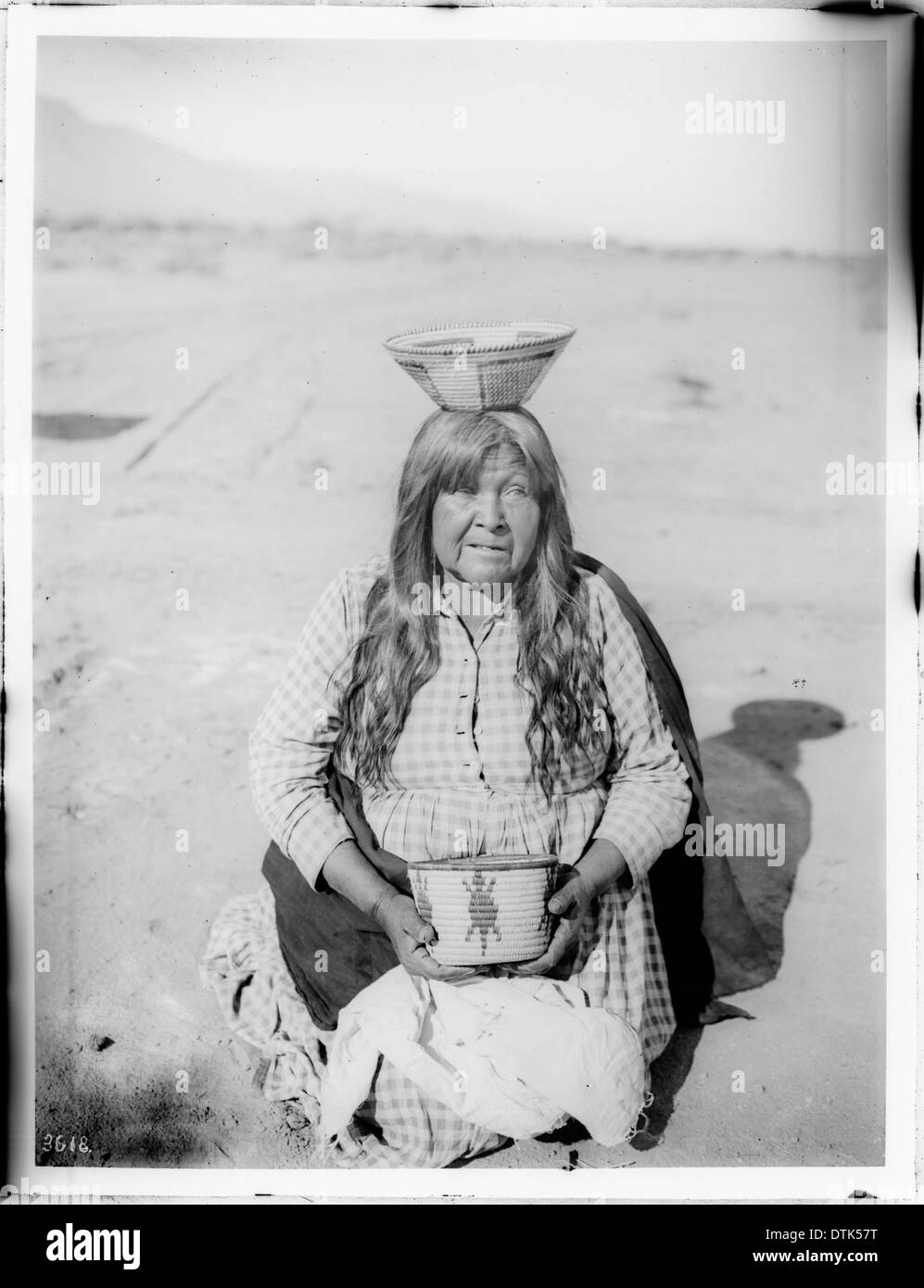 A Pima Indian woman, Jane Sneed, is depicted weaving a basket in ...