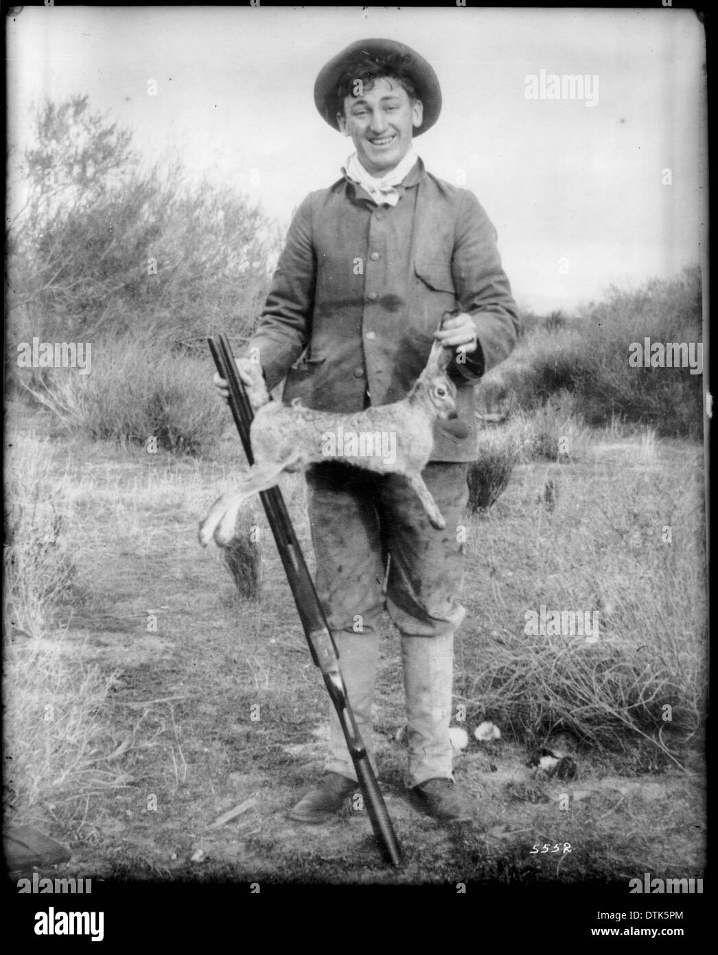 A hunter is seen holding a dead jackrabbit by its ears and tail in this ...