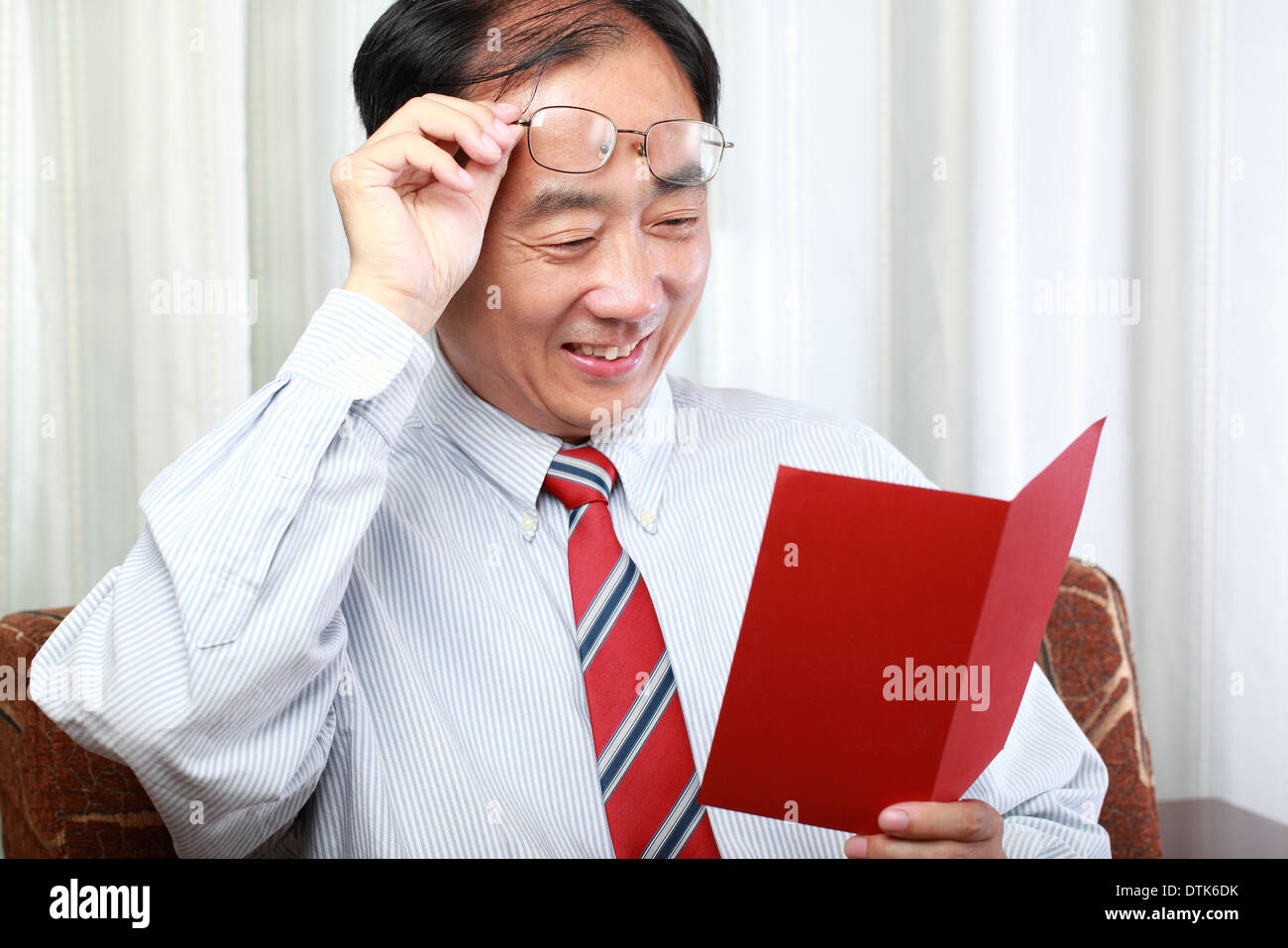 Asian father reading his father's card at home Stock Photo - Alamy