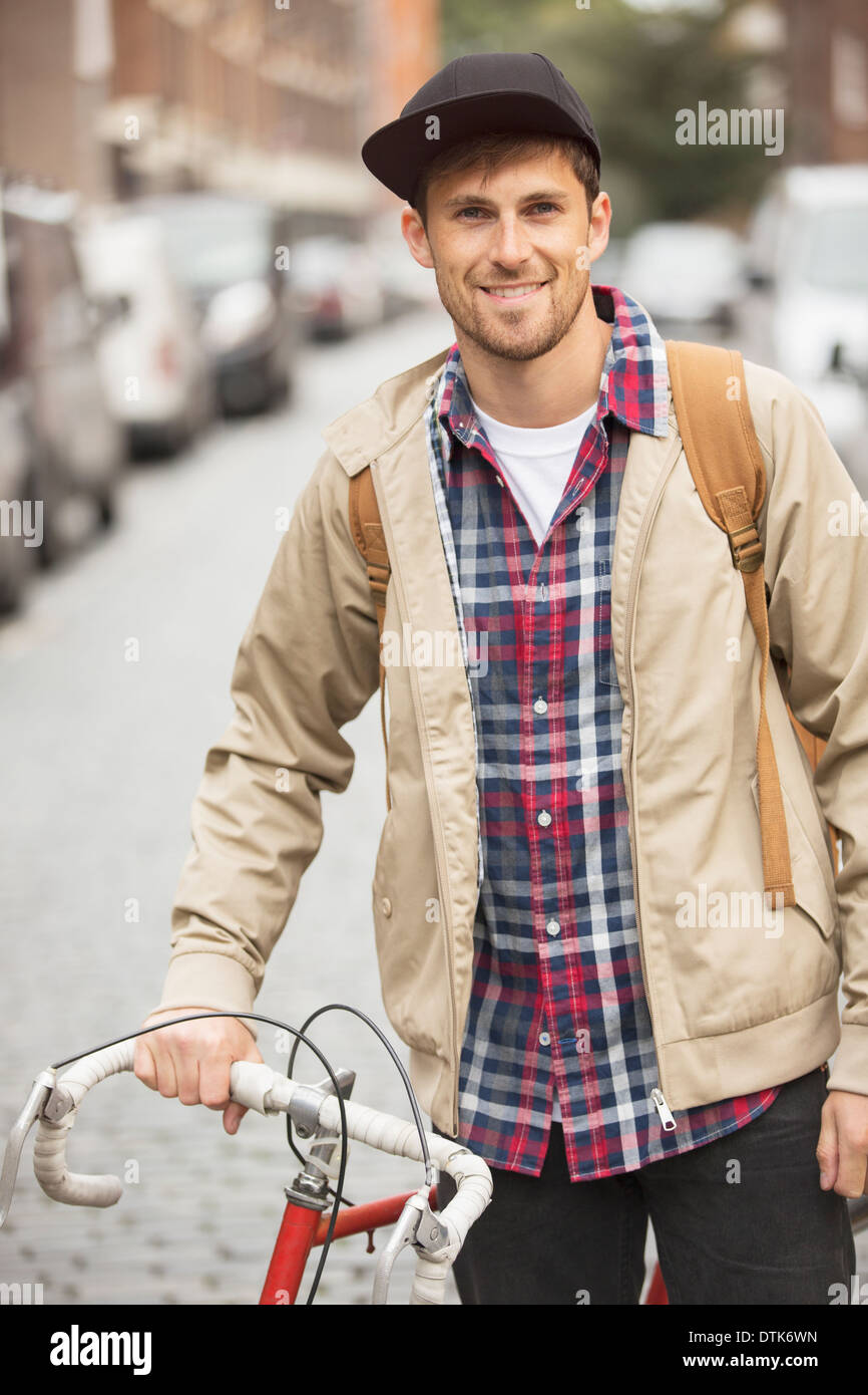 Man pushing bicycle on city street Stock Photo - Alamy
