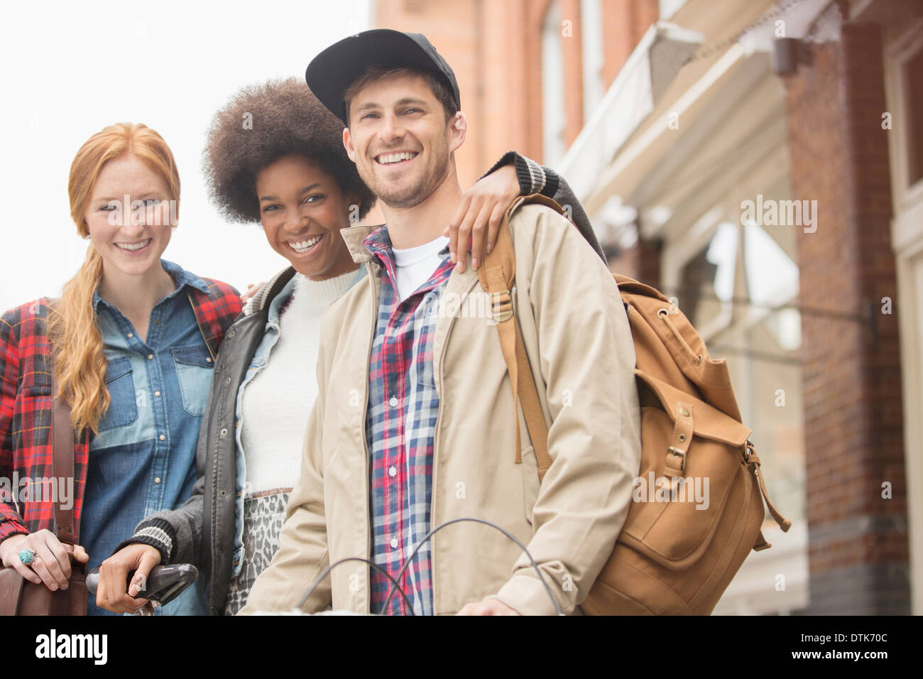 Friends smiling together on city street Stock Photo - Alamy