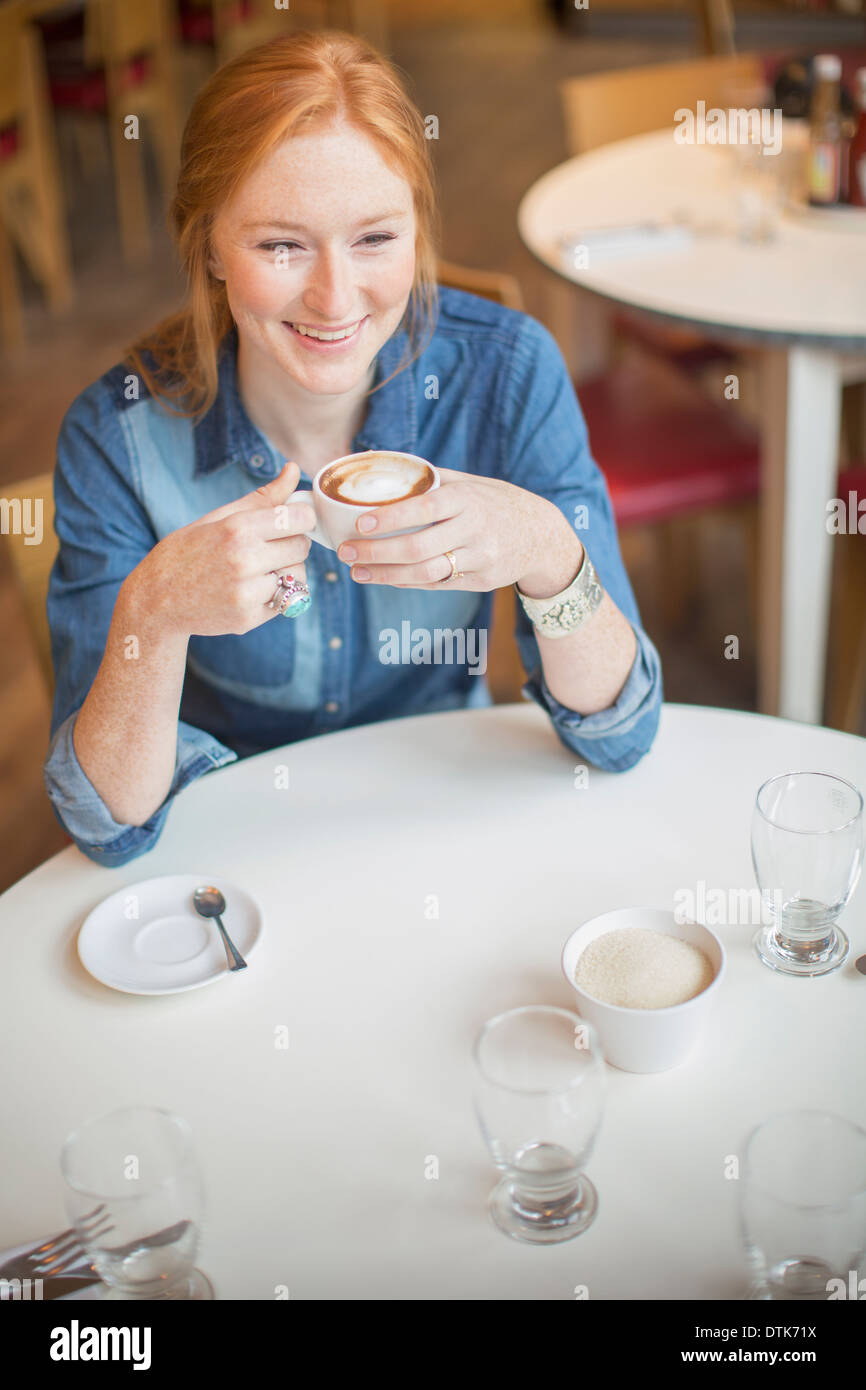 Woman enjoying cup of coffee in cafe Stock Photo - Alamy
