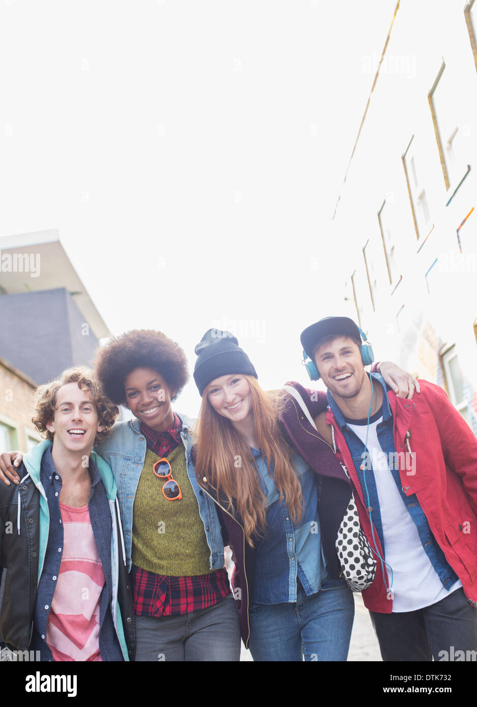 Friends standing together on city street Stock Photo - Alamy