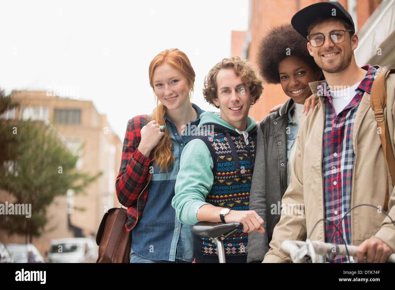 Friends smiling together on city street Stock Photo - Alamy