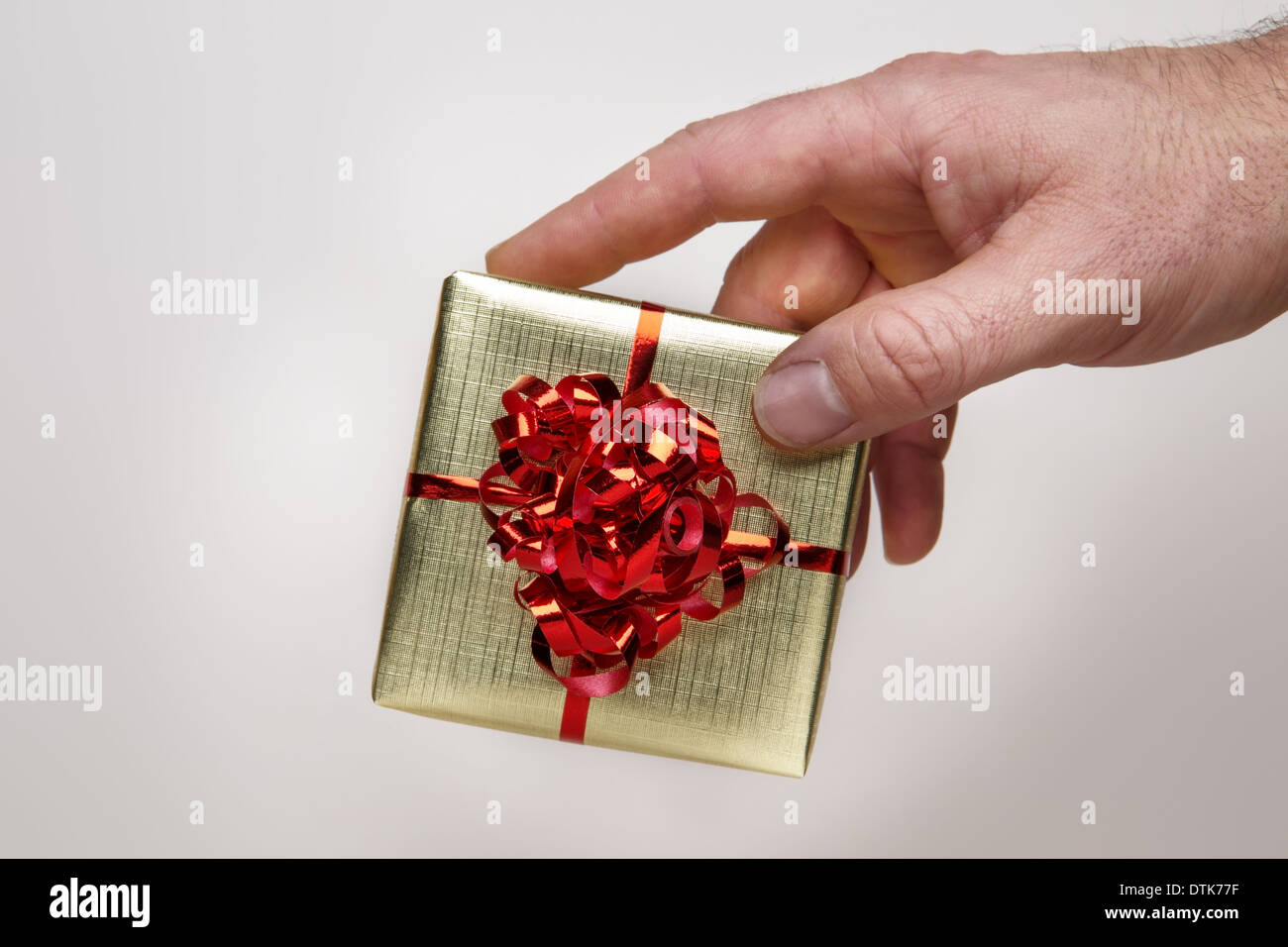 man's hand holding a small gift box with a ribbon around the box Stock ...